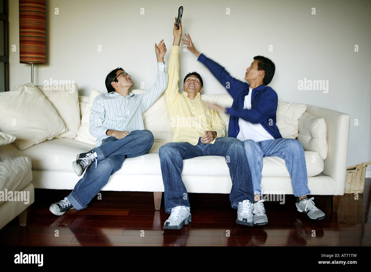 3 Men Fighting for the Remote Control Stock Photo - Alamy