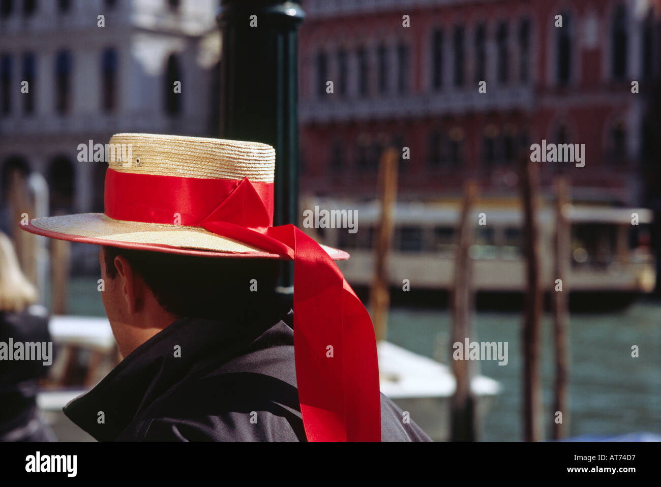 Close up of gondolier wearing traditional hat with red ribbon in Venice ...