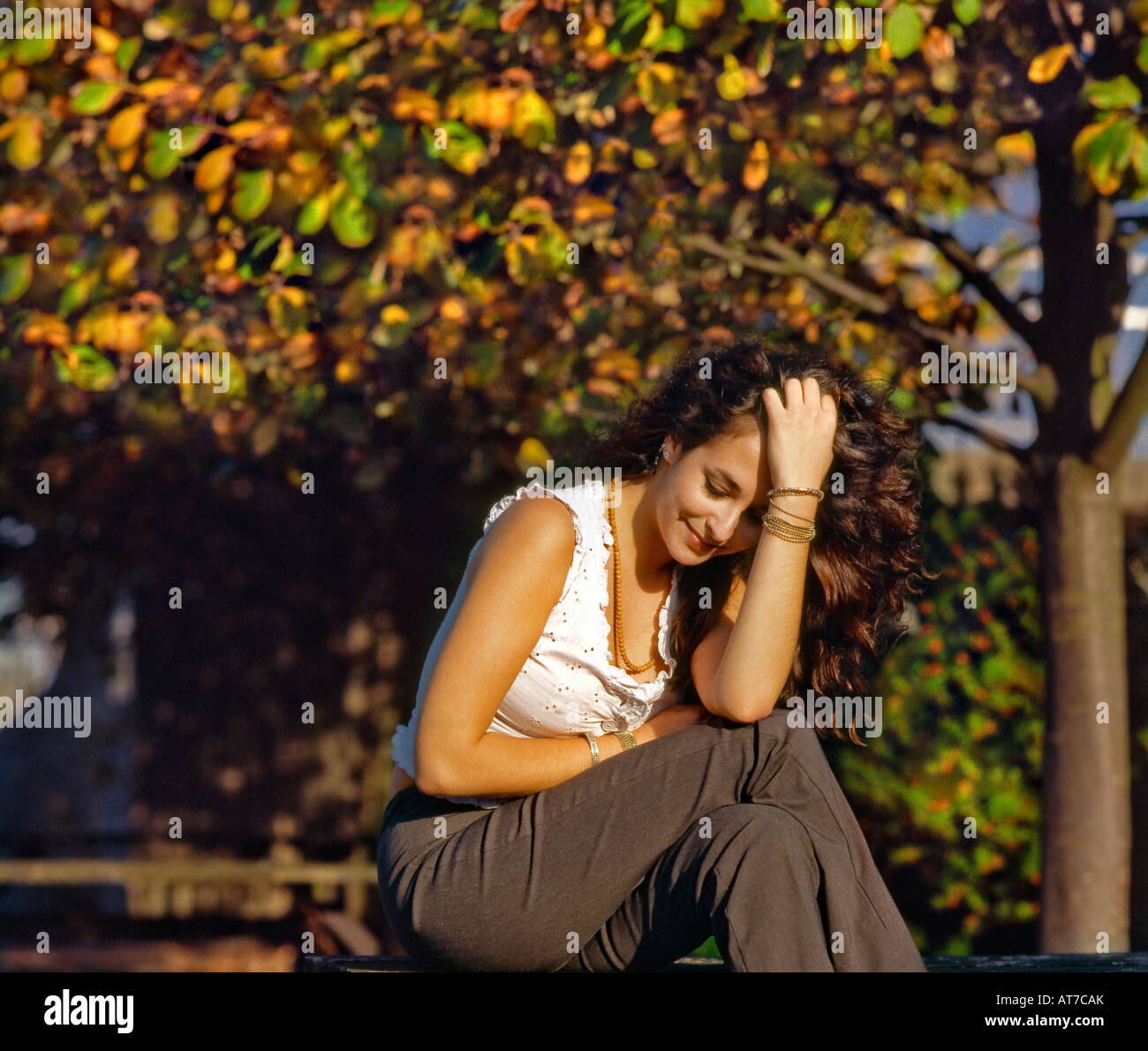 woman sitting thinking hand in hair Stock Photo - Alamy
