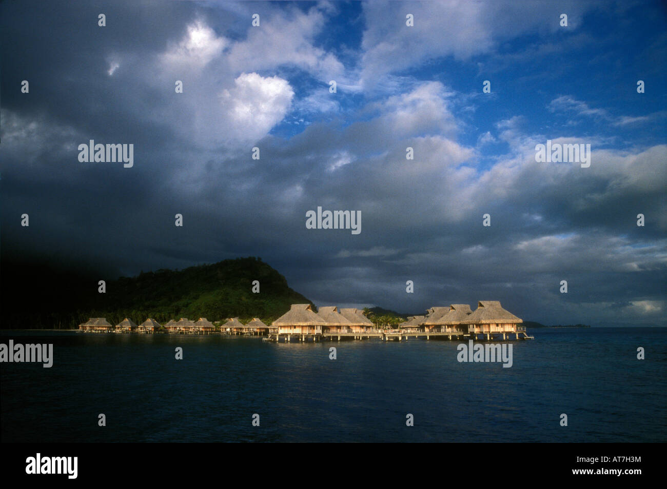 Thatched roof bungalows and brewing storm , Bora Bora Stock Photo - Alamy