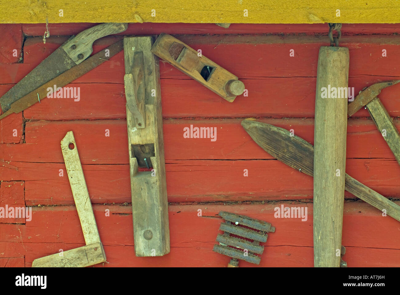old historic tools of carpenter and farmer hanging on red wooden wall ...