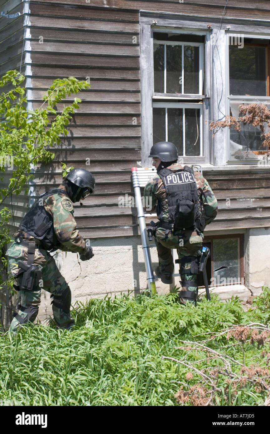 SWAT team members moving towards house to break window and deploy a ...