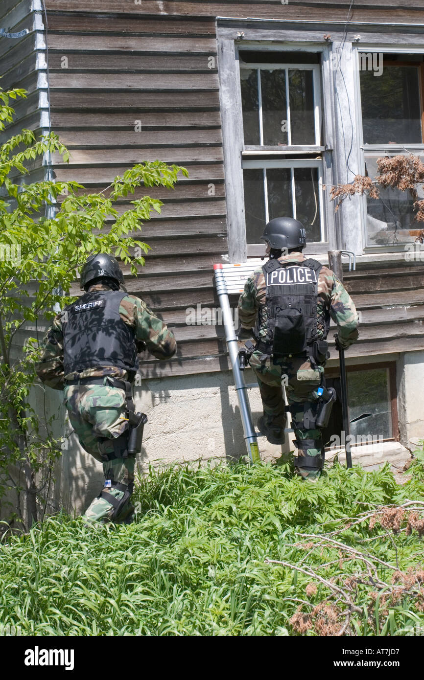 SWAT team members moving towards house to break window and deploy a ...