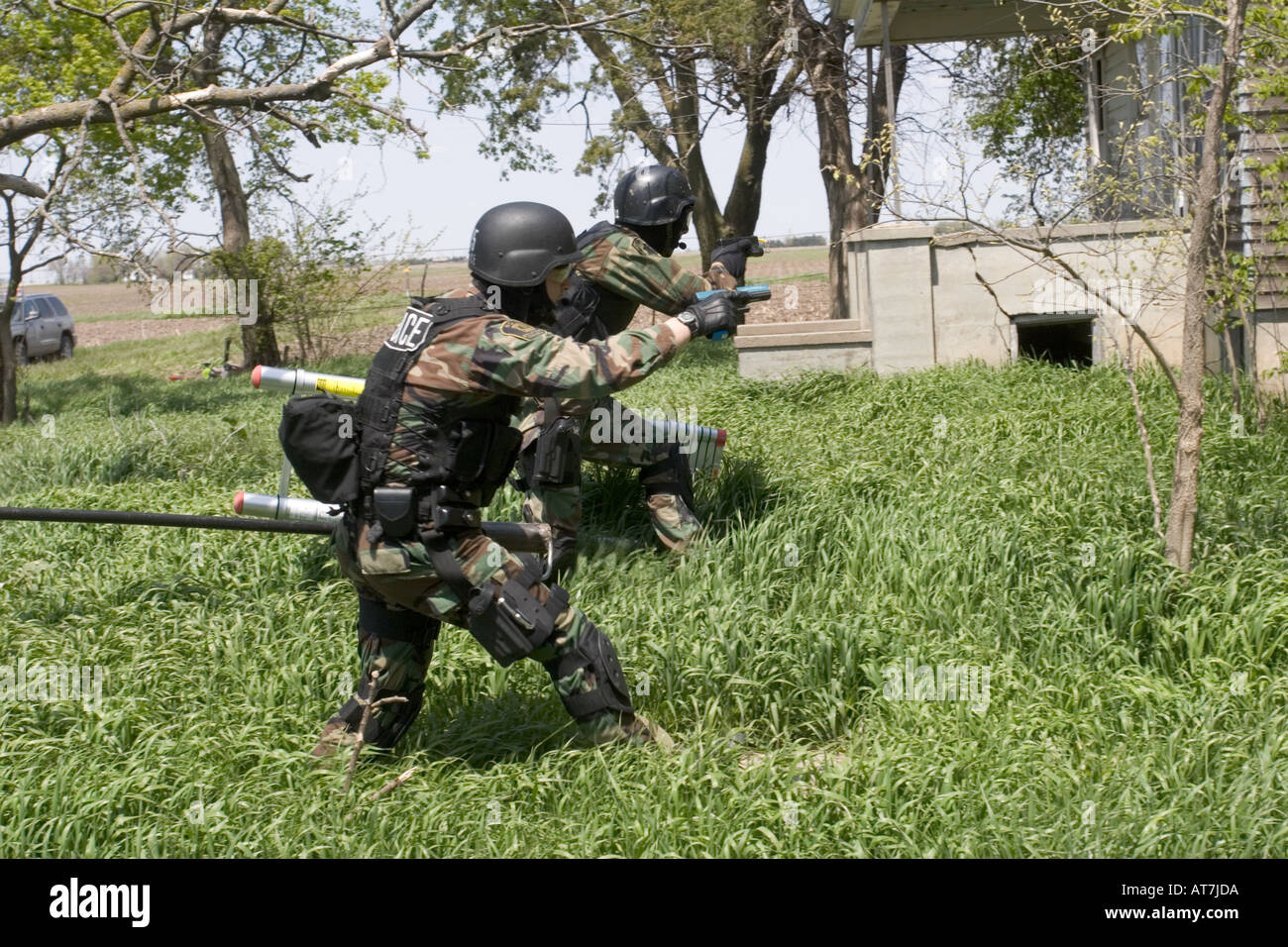 SWAT team members running towards house to break window and deploy a ...