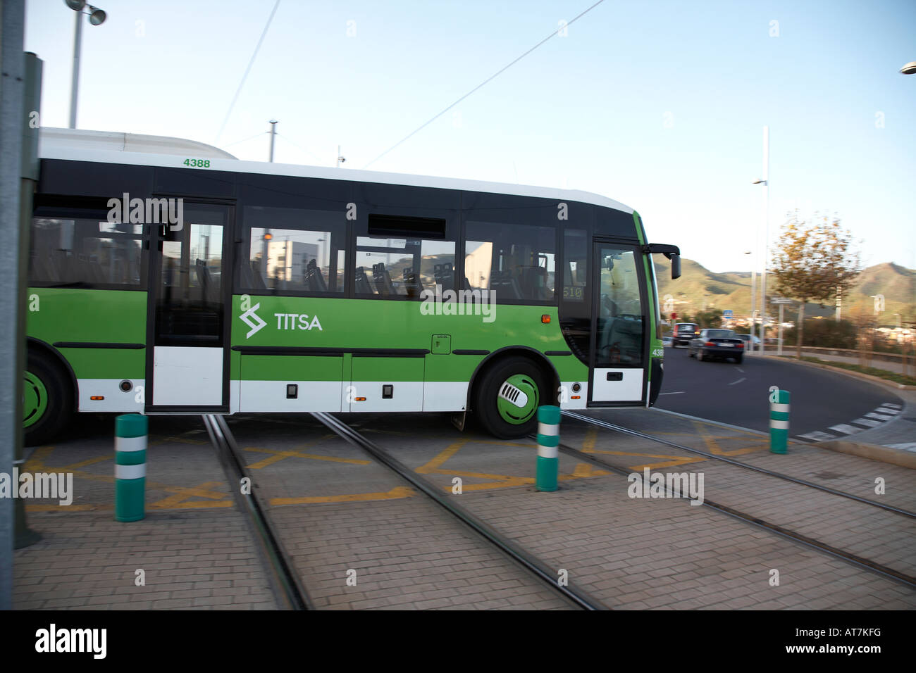 titsa spanish canarian bus travelling around roundabout across tram ...