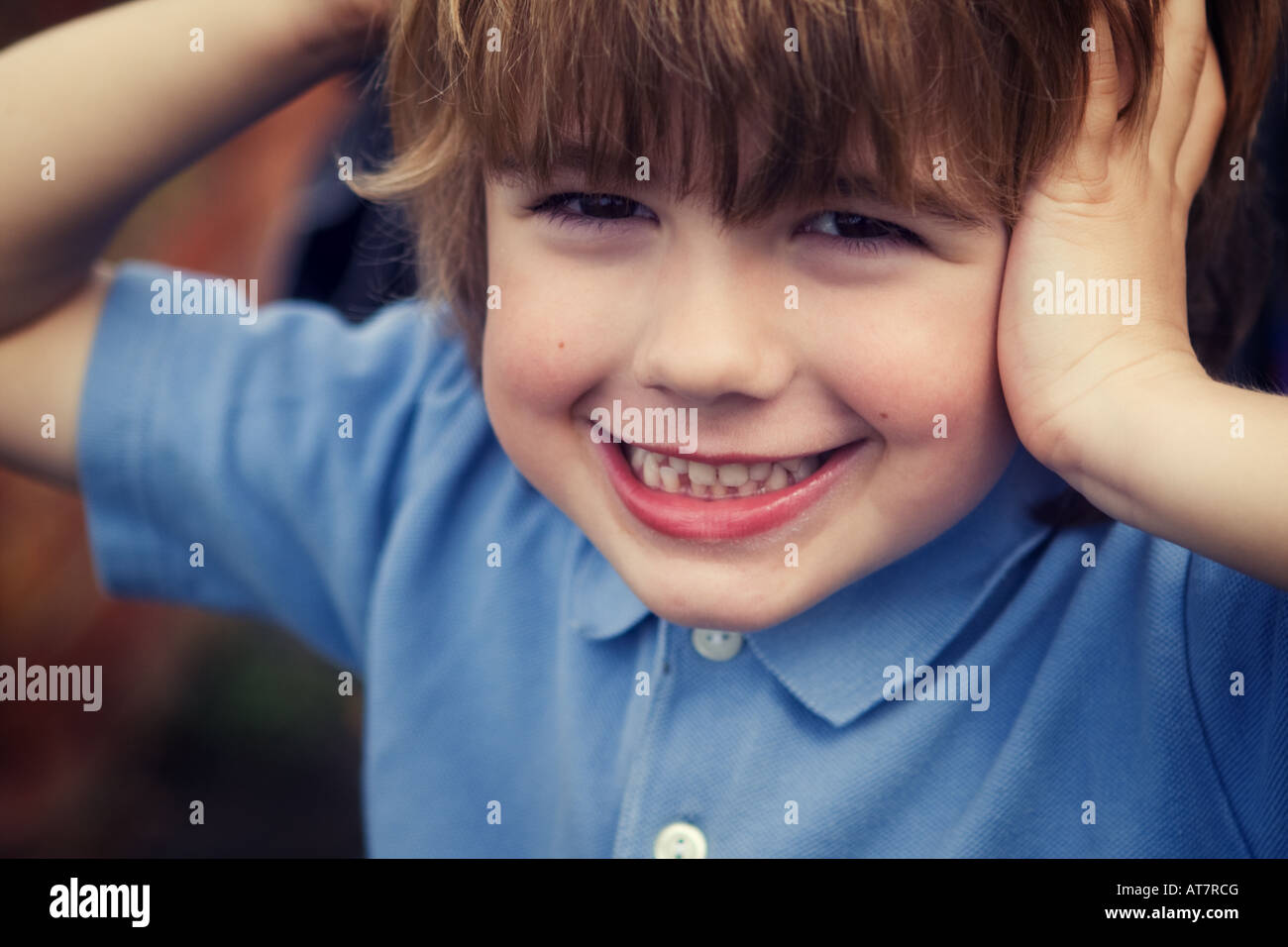 5 year old boy grinning, with his hands up to his head Stock Photo - Alamy