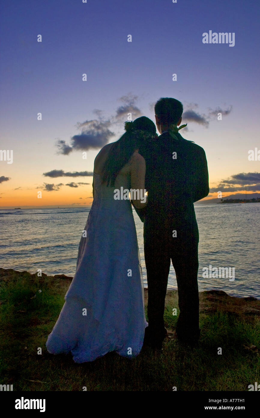 Wedding portrait of bride and groom looking at sunset Stock Photo - Alamy