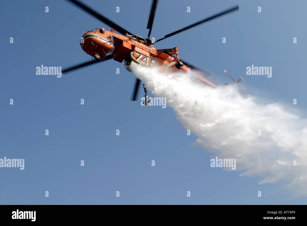 An Erikson Air Crane fire service helicopter drops its payload over a ...