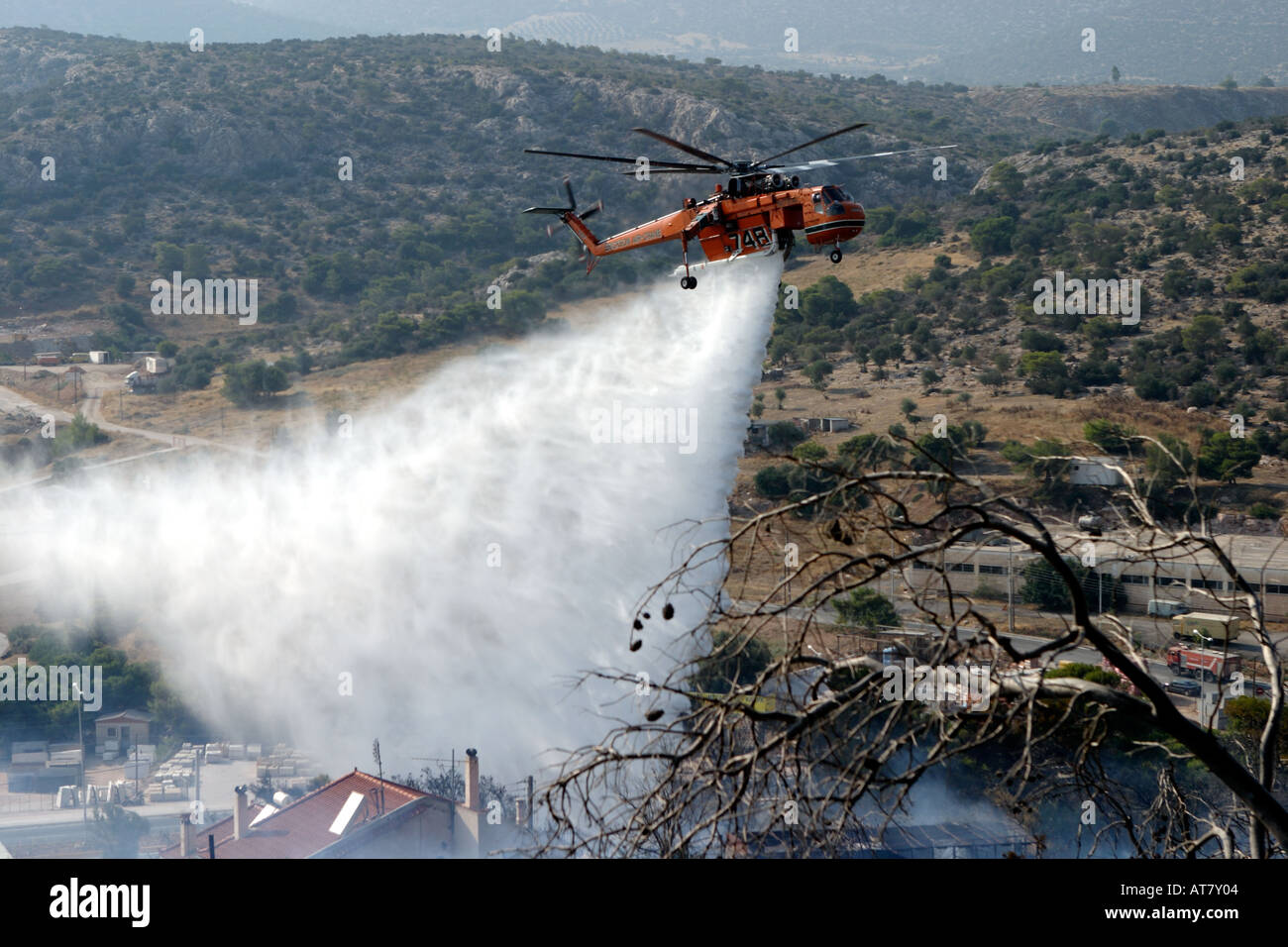An Erikson Air Crane fire service helicopter drops its payload over a ...