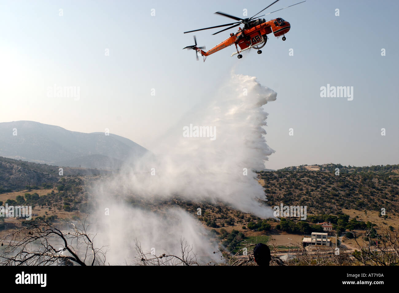 An Erikson Air Crane fire service helicopter drops its payload over a ...