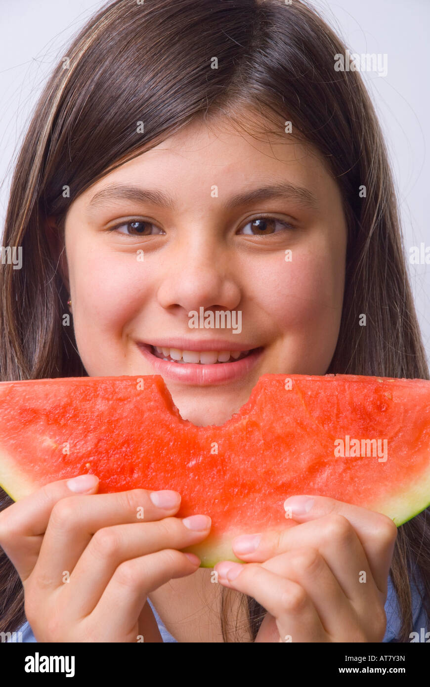 Smiling Young Girl Eating A Slice Of Ripe Seedless Watermelon Stock