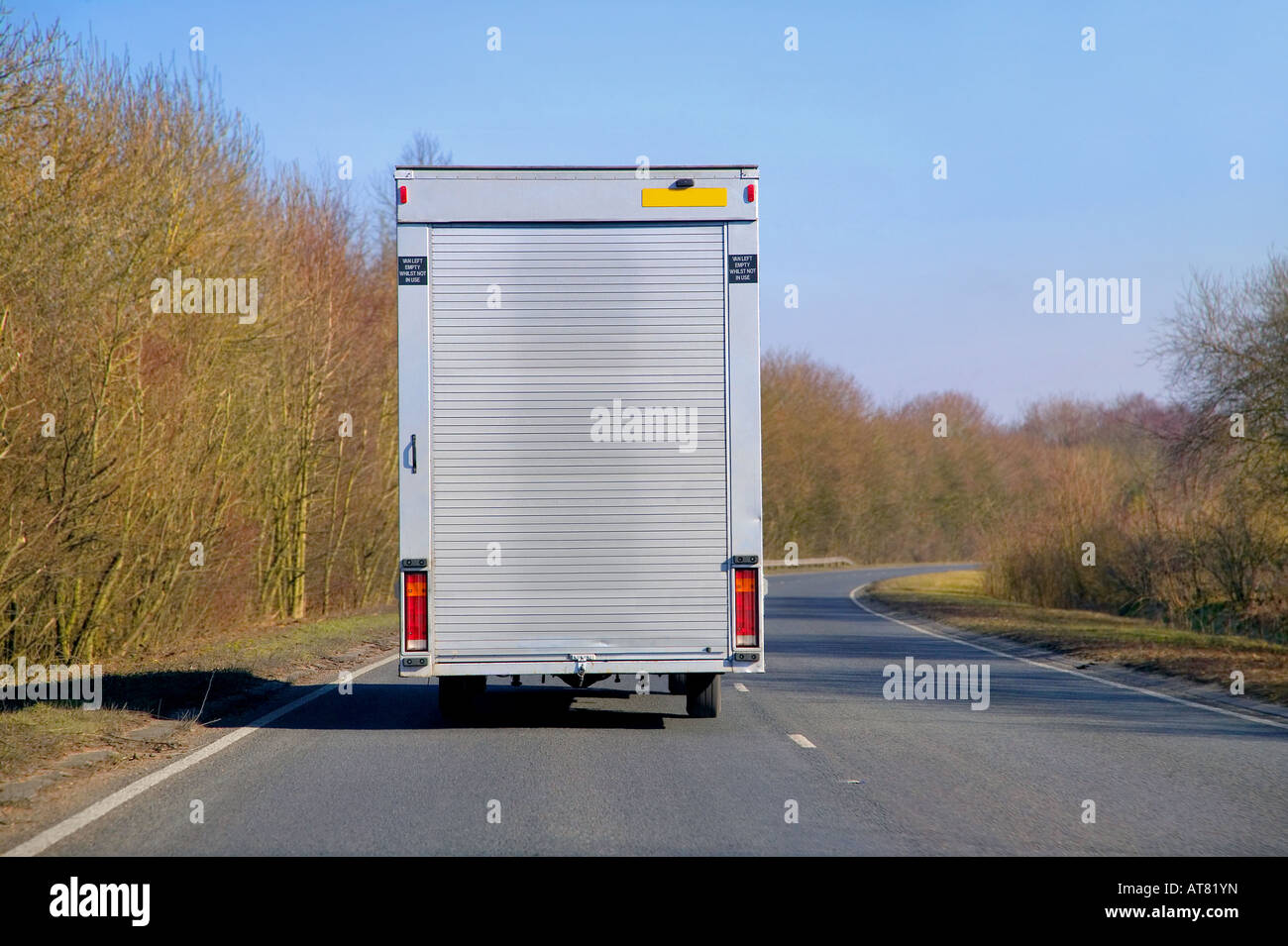 Delivery van with a roller shutter back driving on a road during a ...