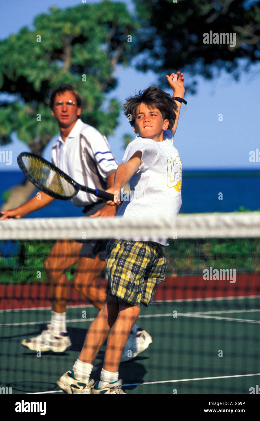 Father and son playing tennis on vacation on the Big Island of Hawaii ...