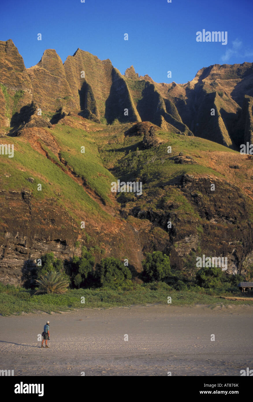 Hiker below fluted cliffs at Kalalau Beach, Na Pali Coast, Kauai Stock ...