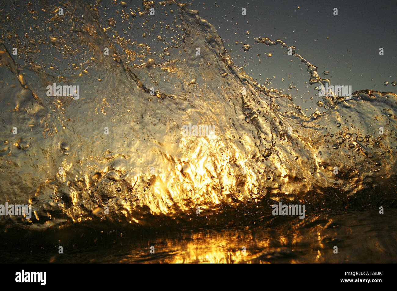 sunset reflecting off of splashing water Stock Photo - Alamy