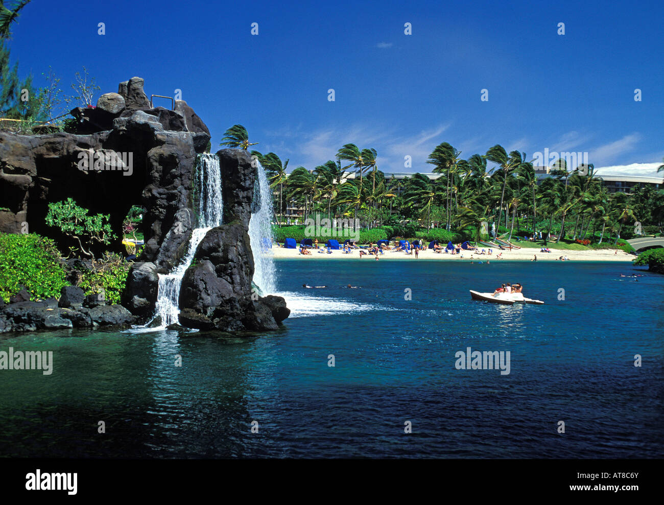 Tourists on a pontoon boat enjoy the blue lagoon and cascading ...