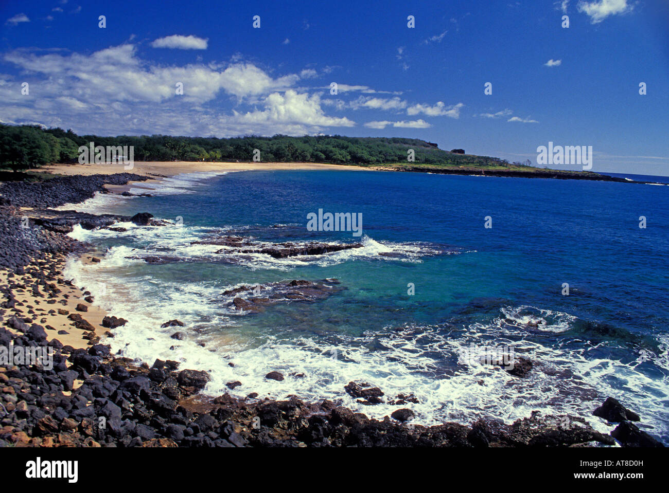 Rocky shoreline with the beautiful blue Pacific Ocean at Manele Bay on ...
