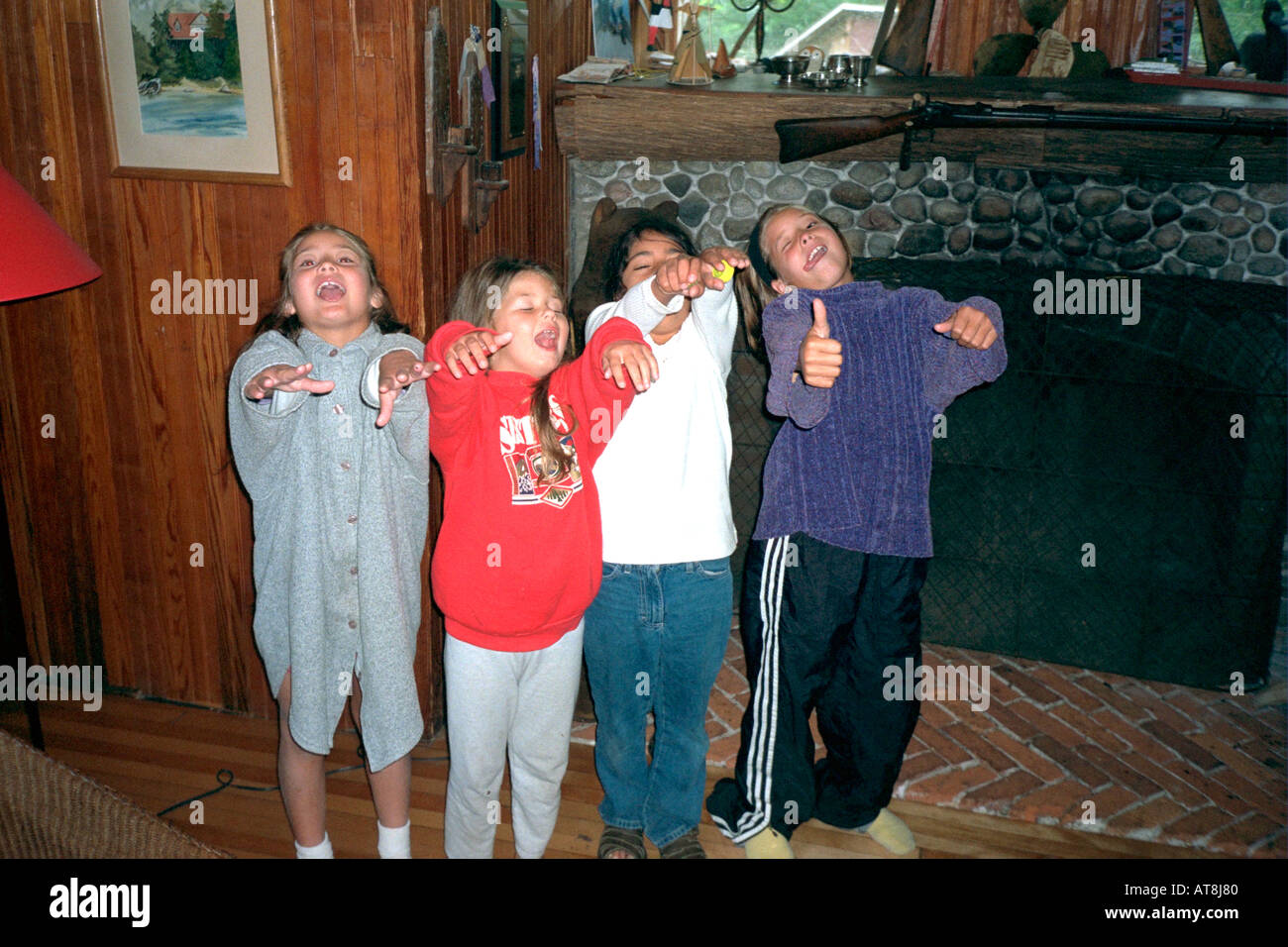 Cousins and siblings ages 5 through 10 holding out arms as charade ...