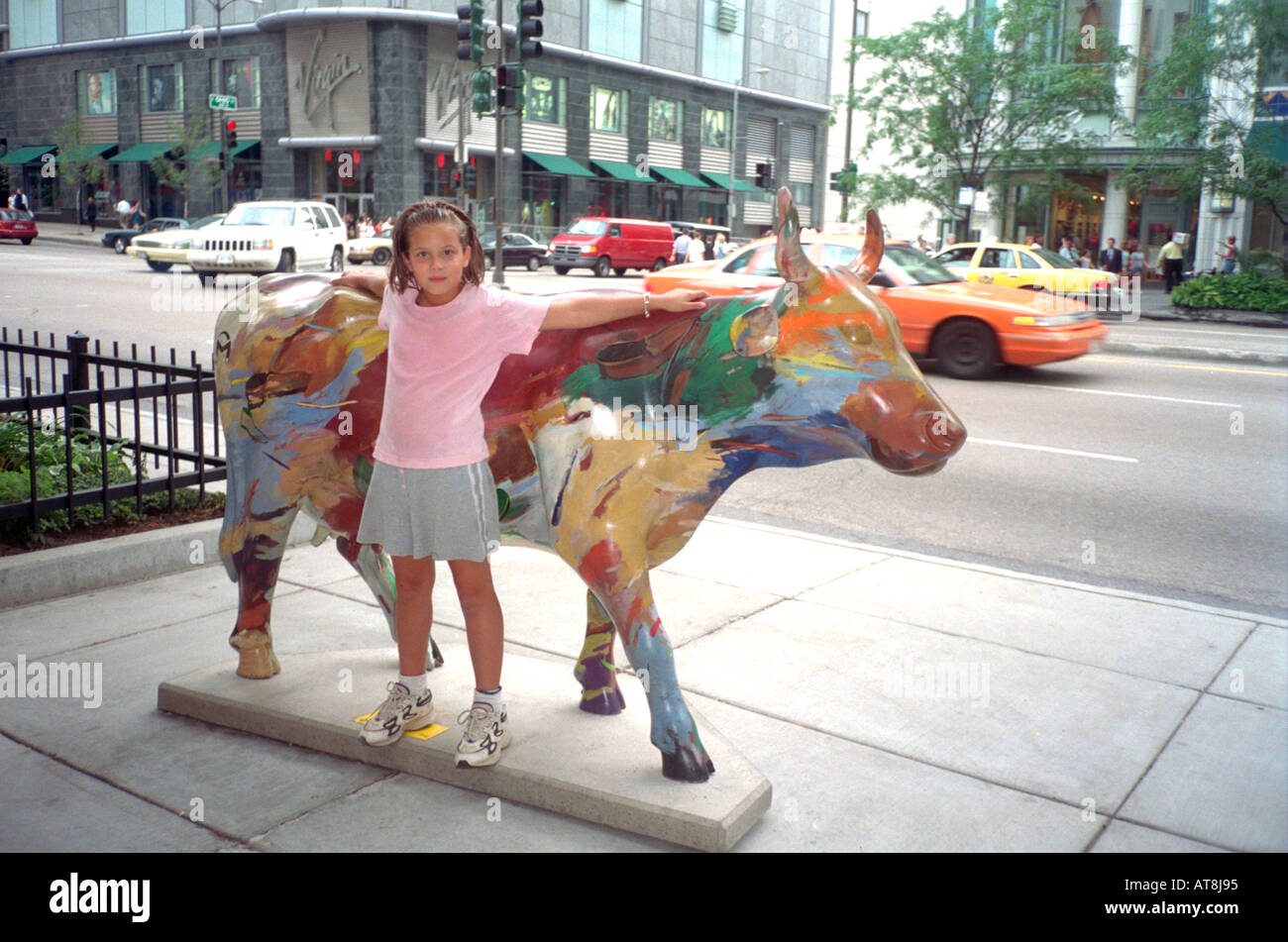 Girl age 9 playing on painted Cows on Parade sculpture art piece ...