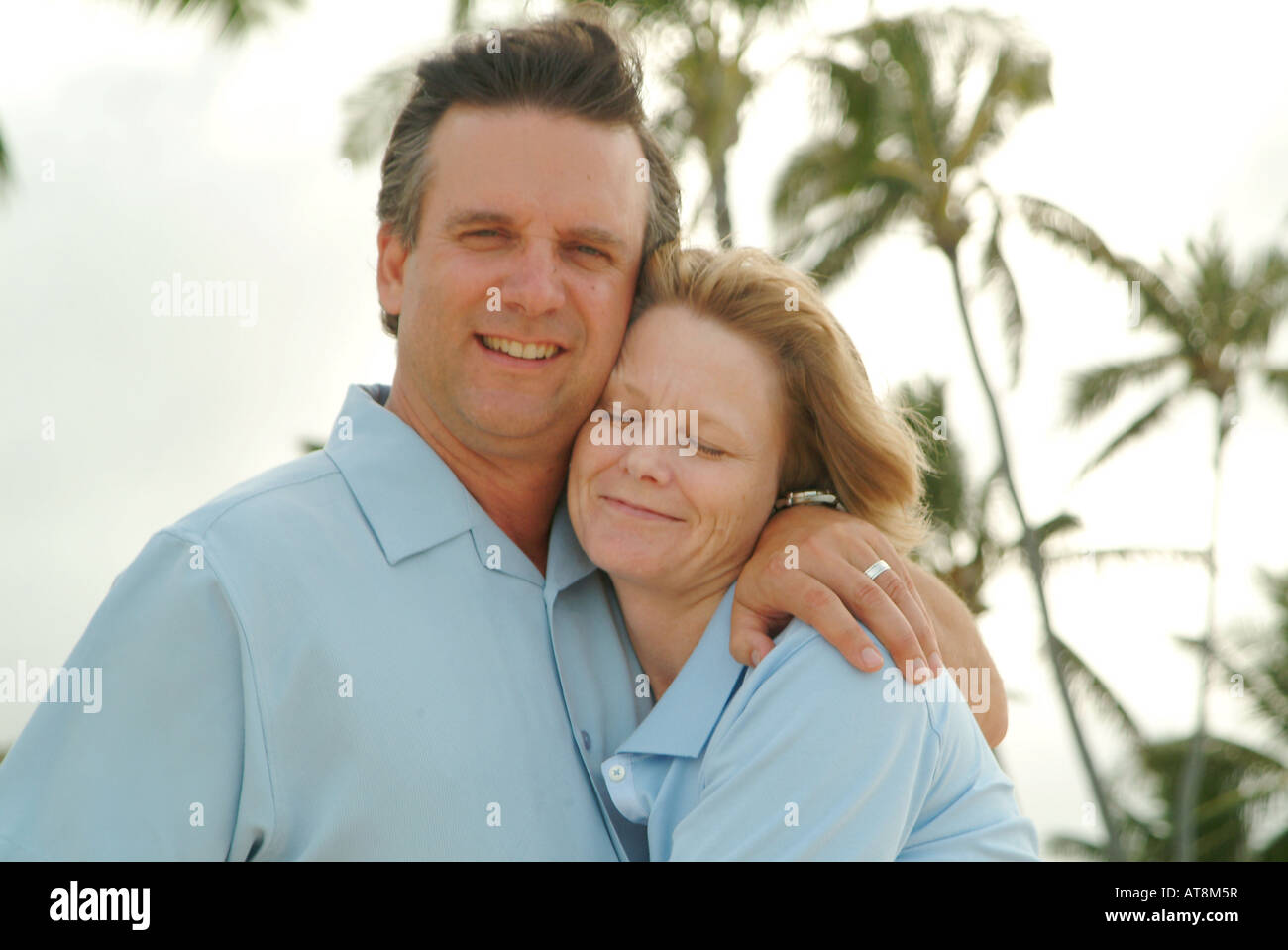 Portrait of a loving couple hugging near palm trees Stock Photo - Alamy