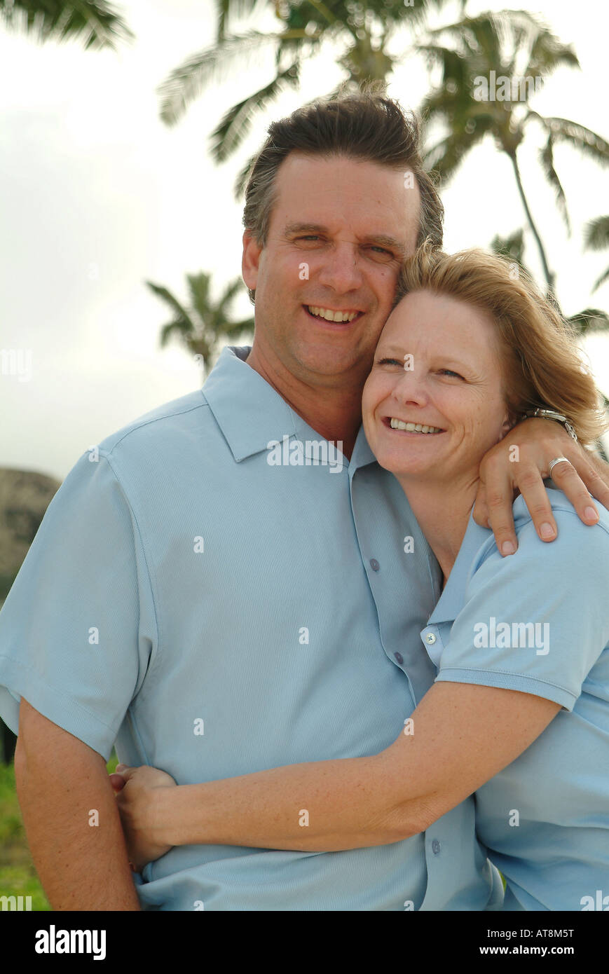 Portrait of a loving couple hugging near palm trees Stock Photo - Alamy
