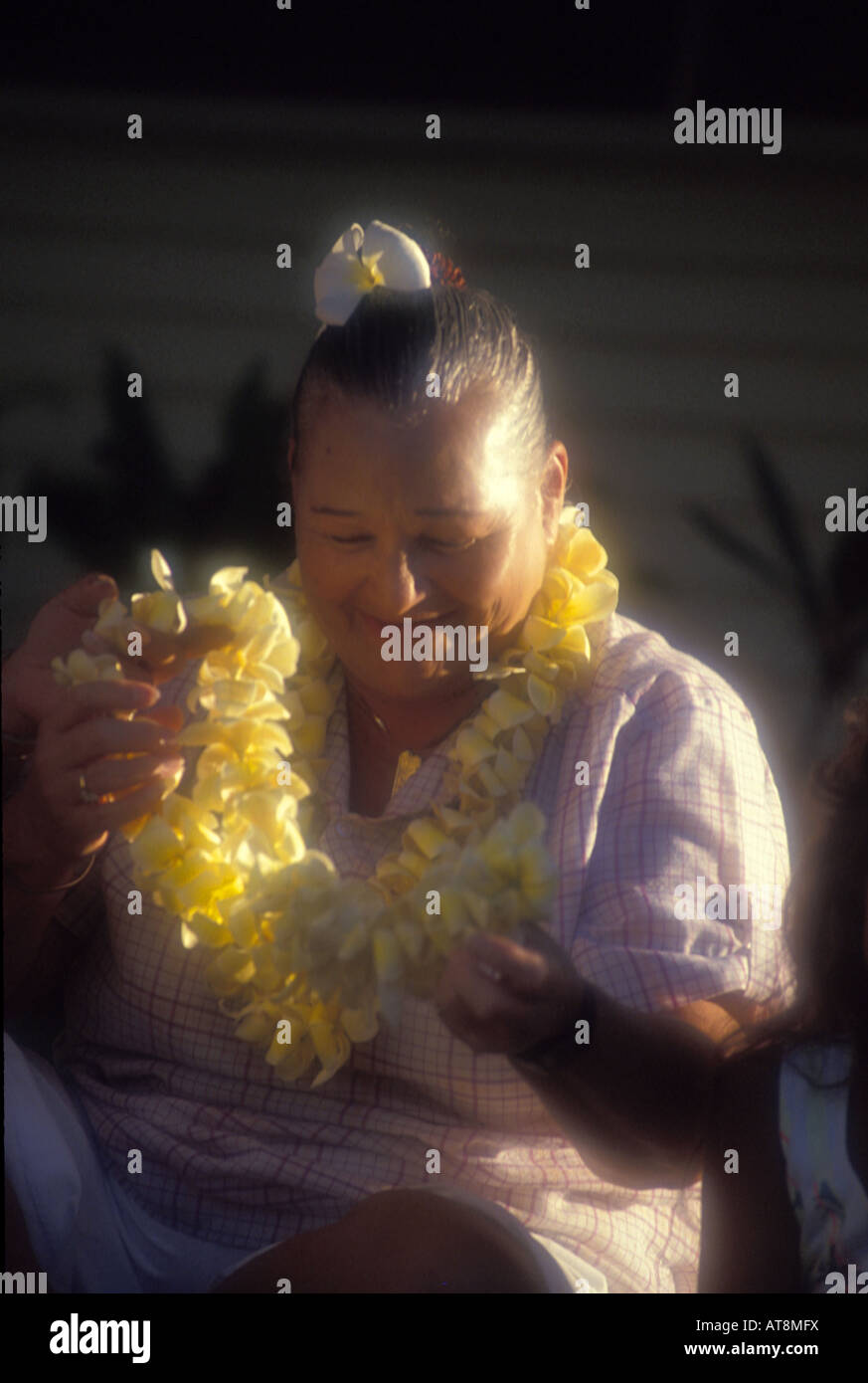 Auntie Flo stringing plumeria lei Stock Photo - Alamy