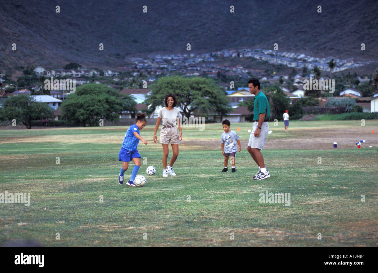Family playing soccer in an open field in Hawaii Kai, Oahu Stock Photo ...