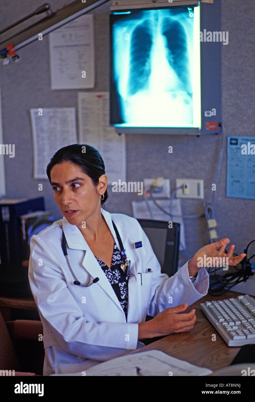 Dr Emily Cooper works at a computer in her office with an X-ray on the ...