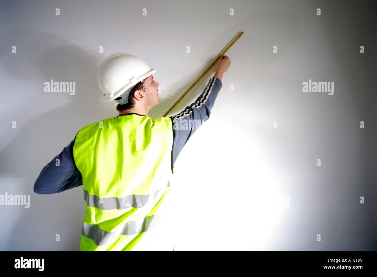 Construction worker measuring the dimesion of a wall Stock Photo - Alamy