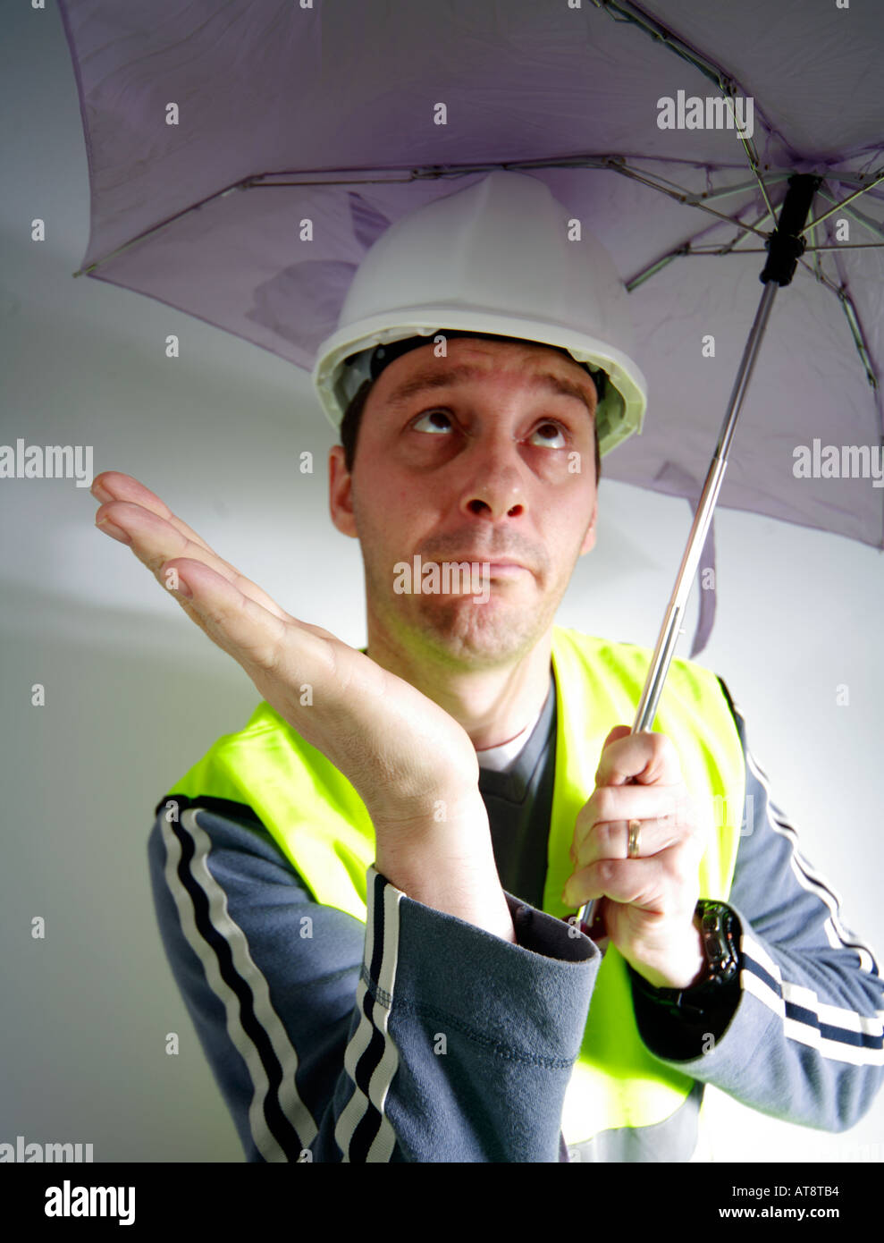 Construction worker waits for it to stop raining Stock Photo - Alamy