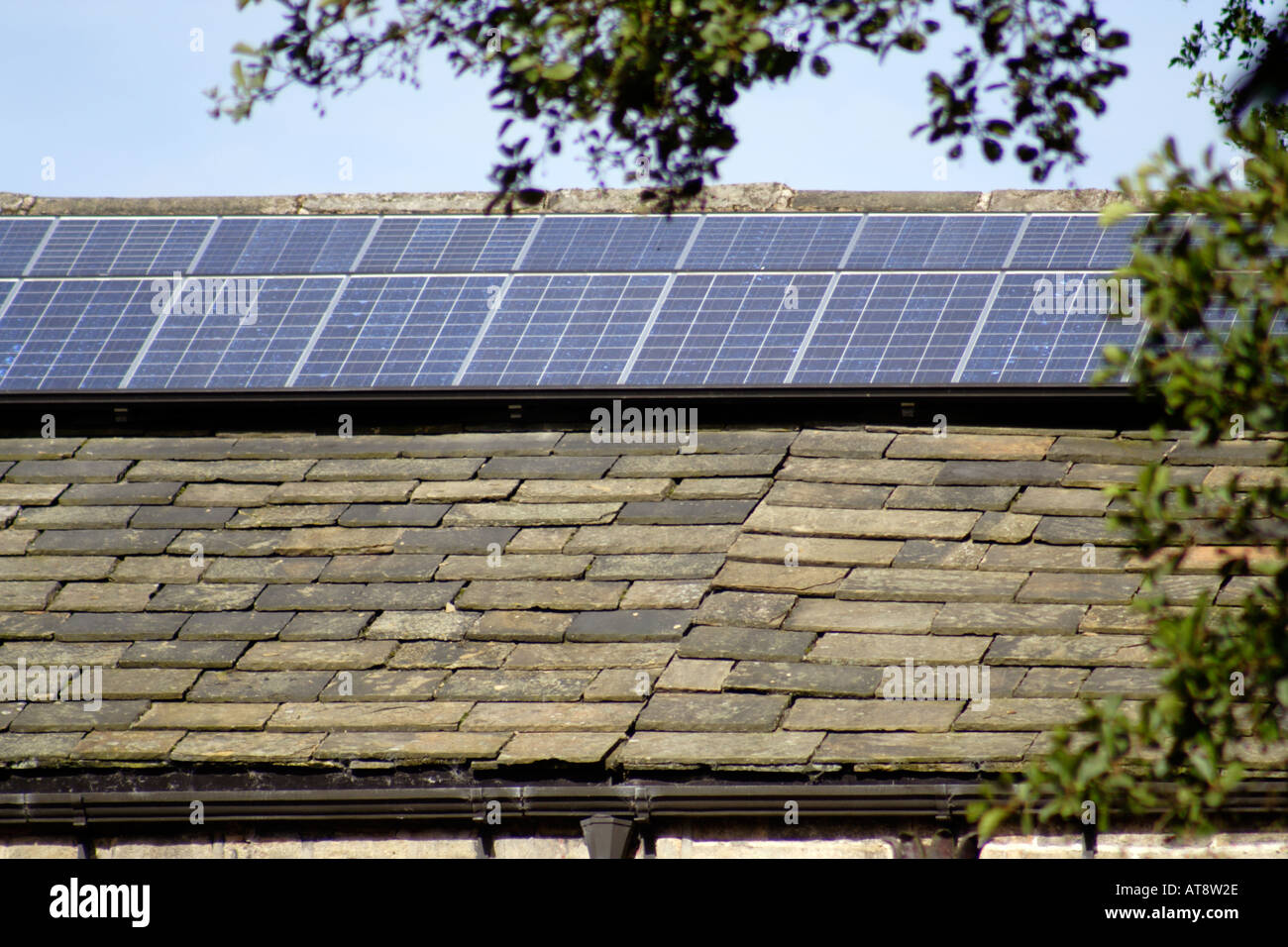 Solar panels on a traditionally stone roofed house UK Stock Photo - Alamy