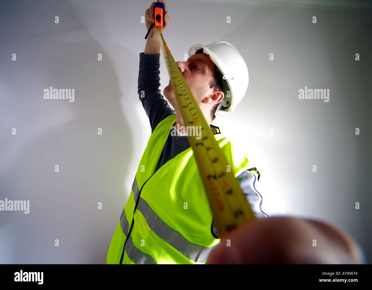 Construction worker measuring something Stock Photo - Alamy