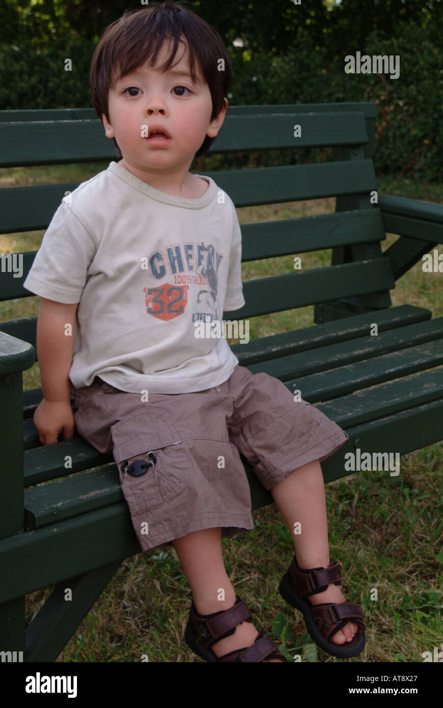 Little boy sitting on a bench Stock Photo - Alamy