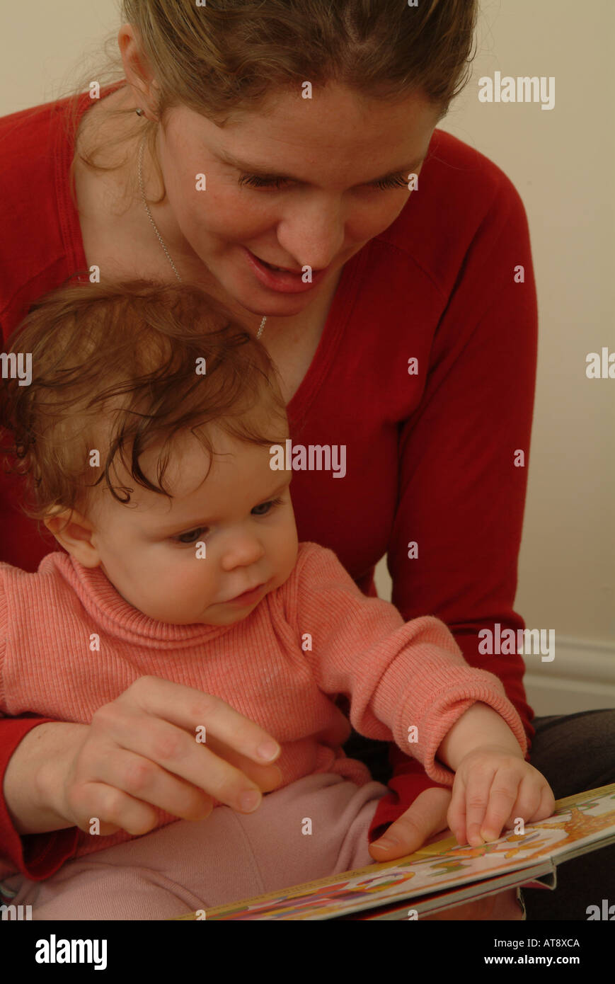Mother and baby reading a book together Stock Photo - Alamy