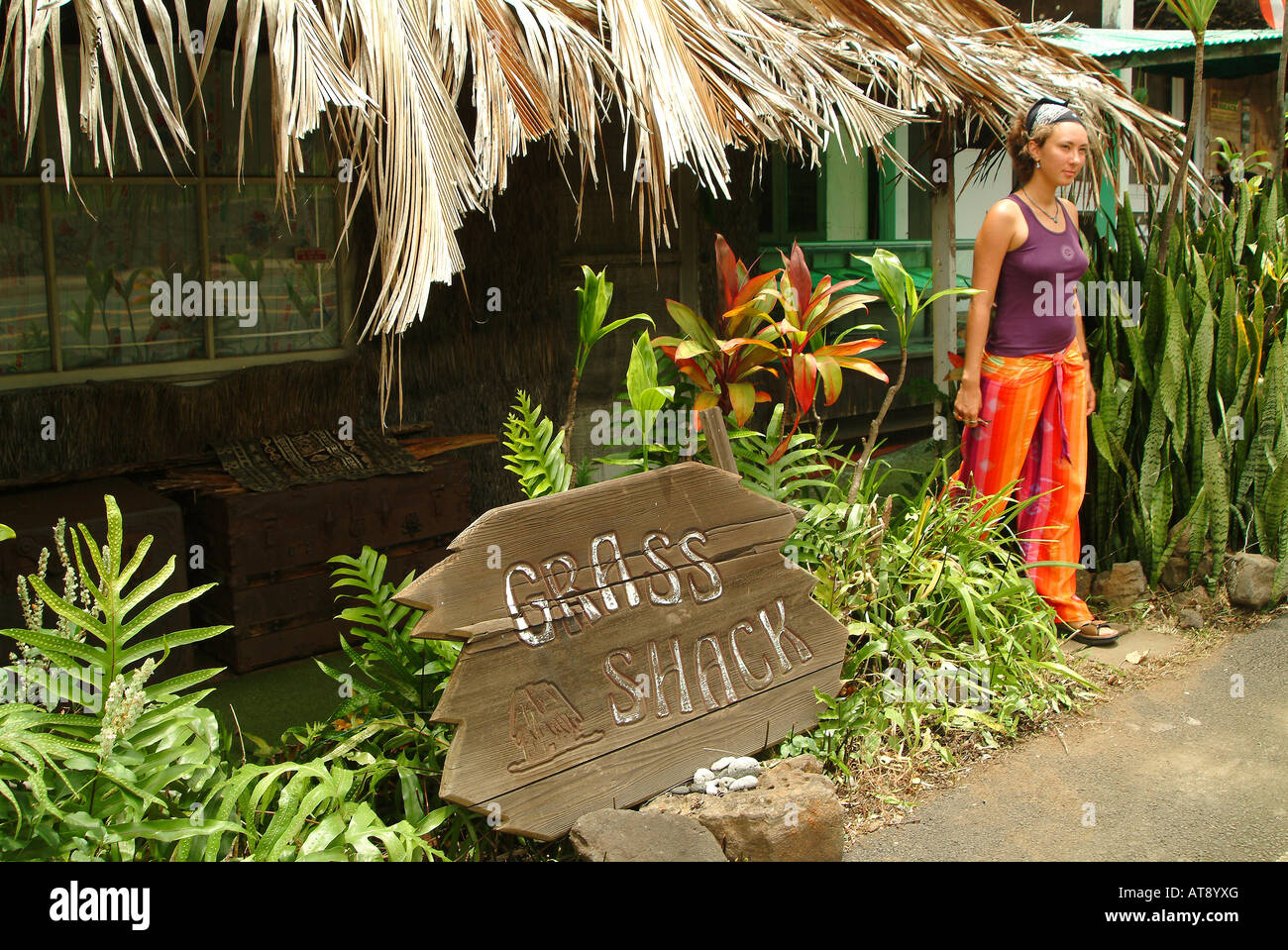 Young woman, age 20, at the famous grass shack just south of Kona above ...