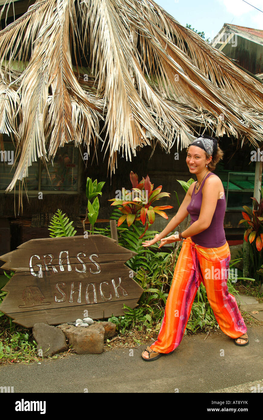 Young woman, age 20, at the famous grass shack just south of Kona above ...
