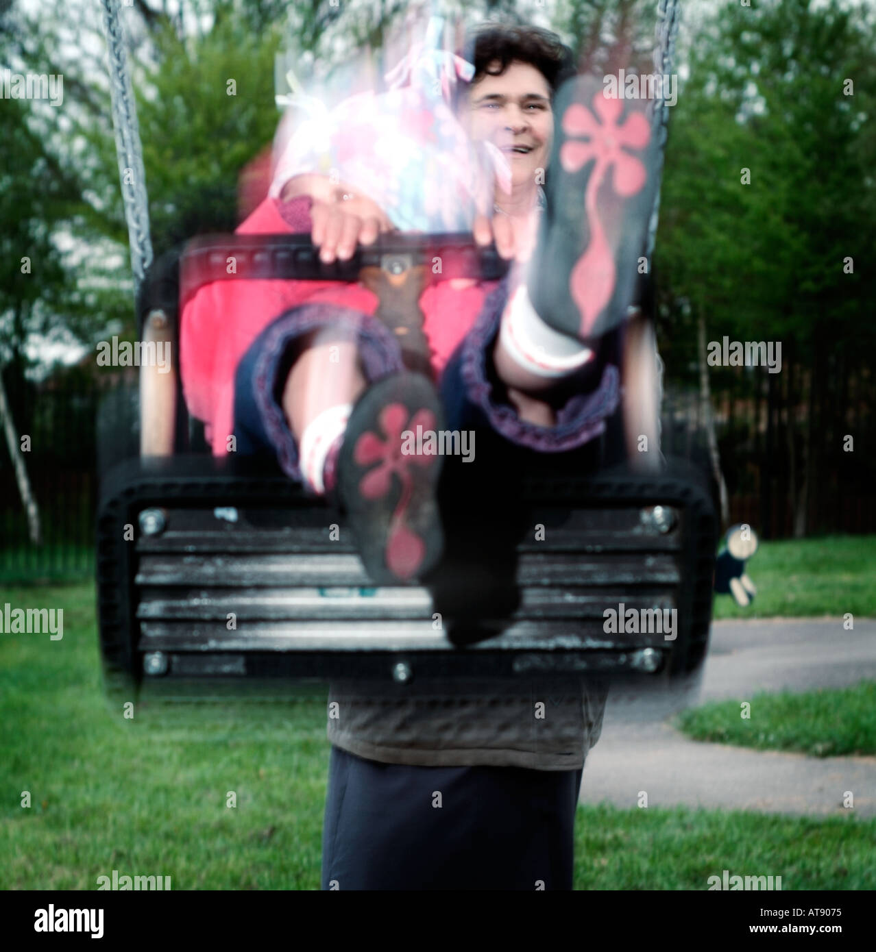 grandmother pushing a child on a swing Stock Photo - Alamy