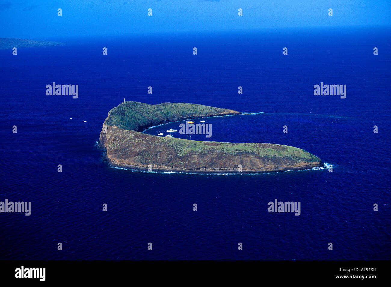 Aerial view of Molokini with boats moored off this partially exposed ...