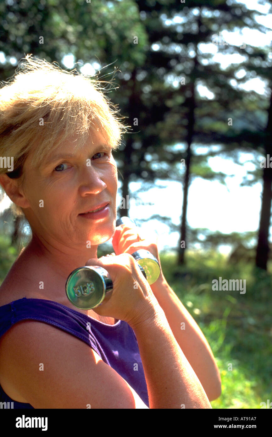 Woman age 56 lifting dumbbells outdoor workout. Big La Salle Island Les ...