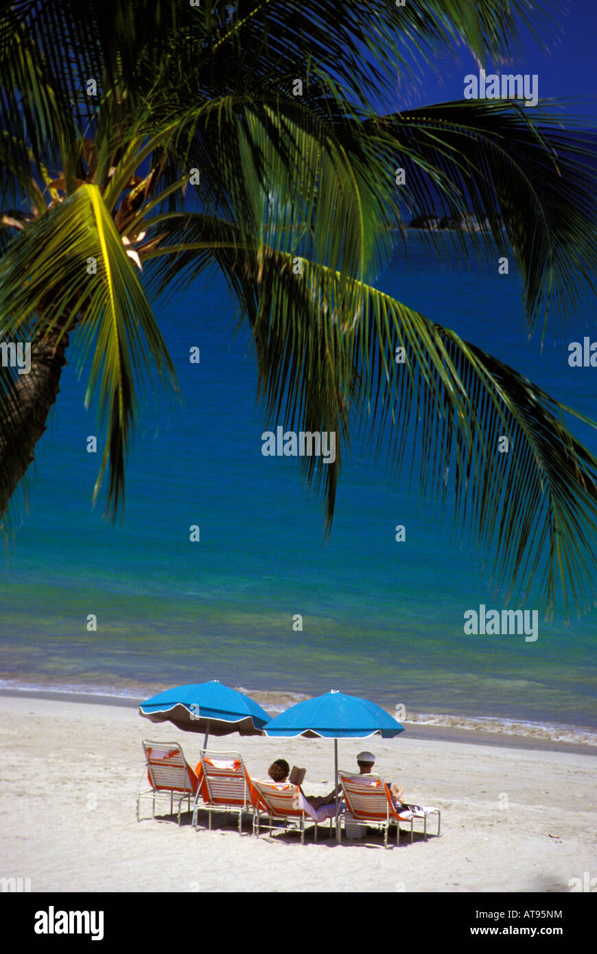 People in beach chairs on the white sand fronting Mauna Kea Beach Hotel ...