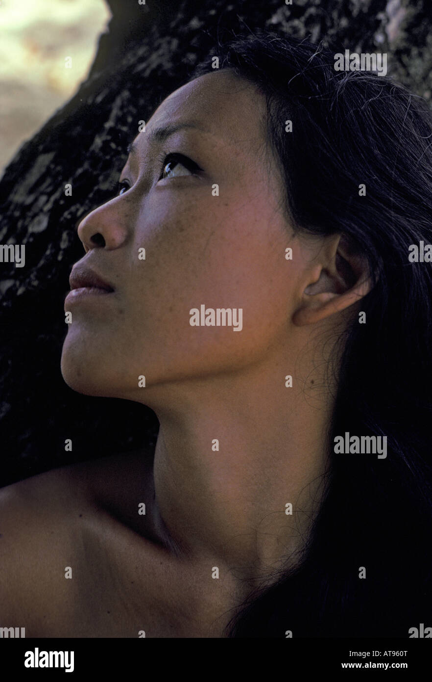 Outdoor side view portrait of a beautiful young multi-ethnic woman ...