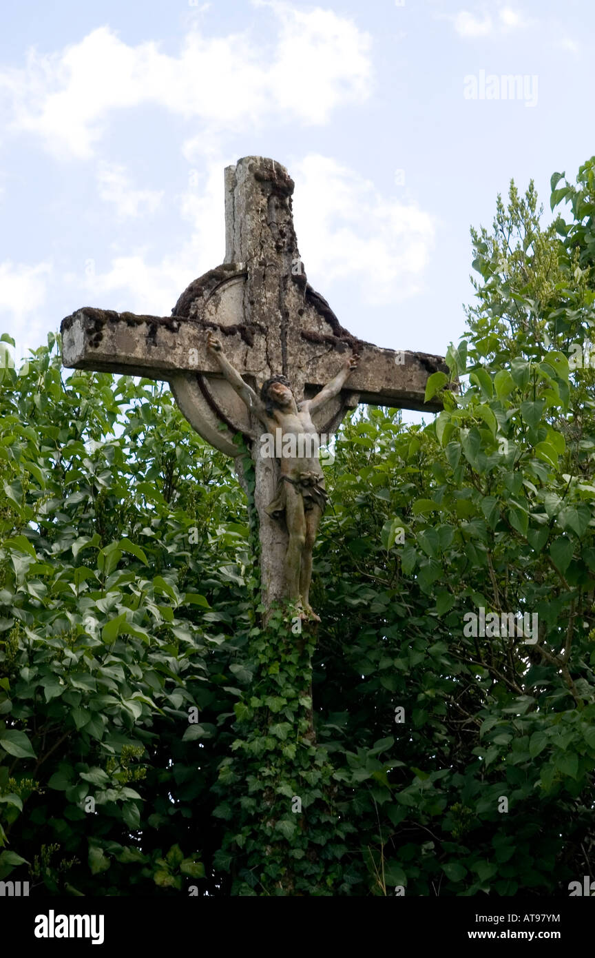 stone cross with Jesus christ in the crucified postion at a french ...