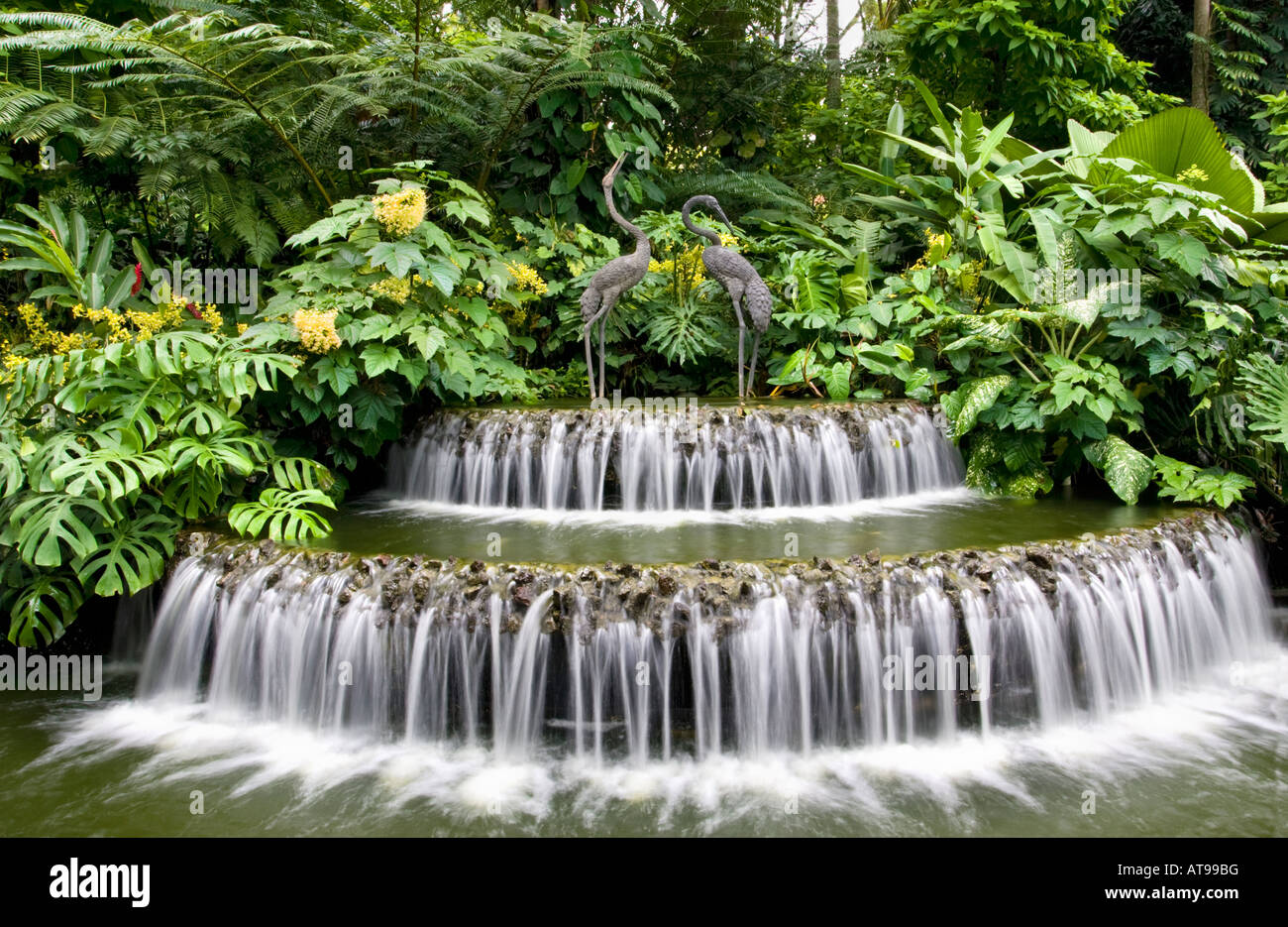 A waterfall fountain and crane sculptures in Singapore Botanic Gardens ...