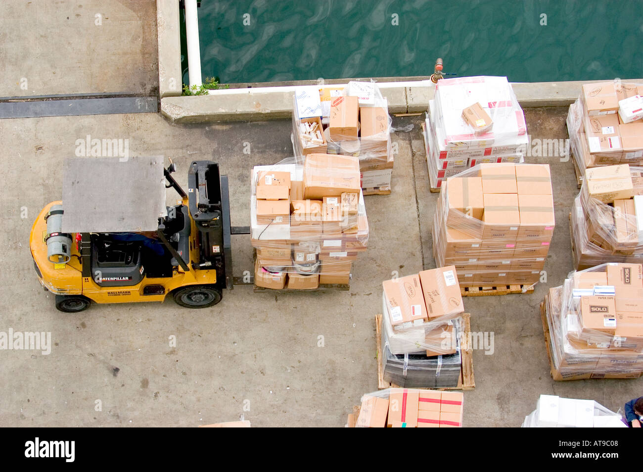 Fork lift vehicles unload supplies from semi truck trailers Stock Photo ...