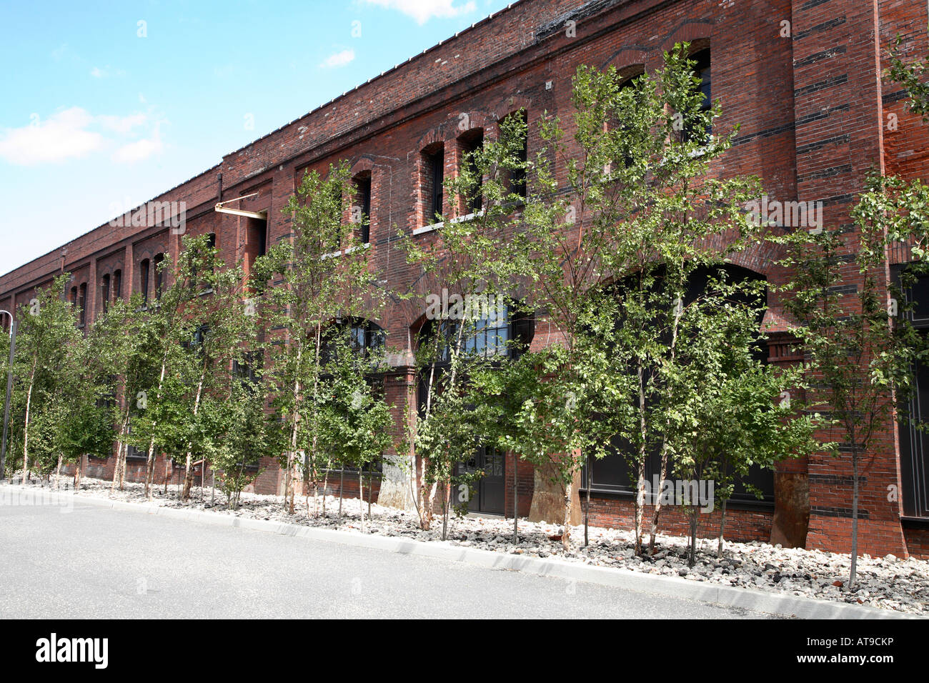 Brick two story building with bays of roman arches filled with many ...