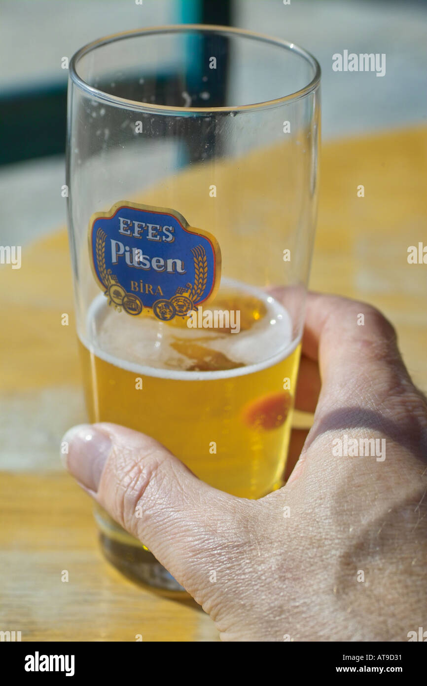 Grasping half full glass of Efes beer Turkish lager Turkish law has a ...