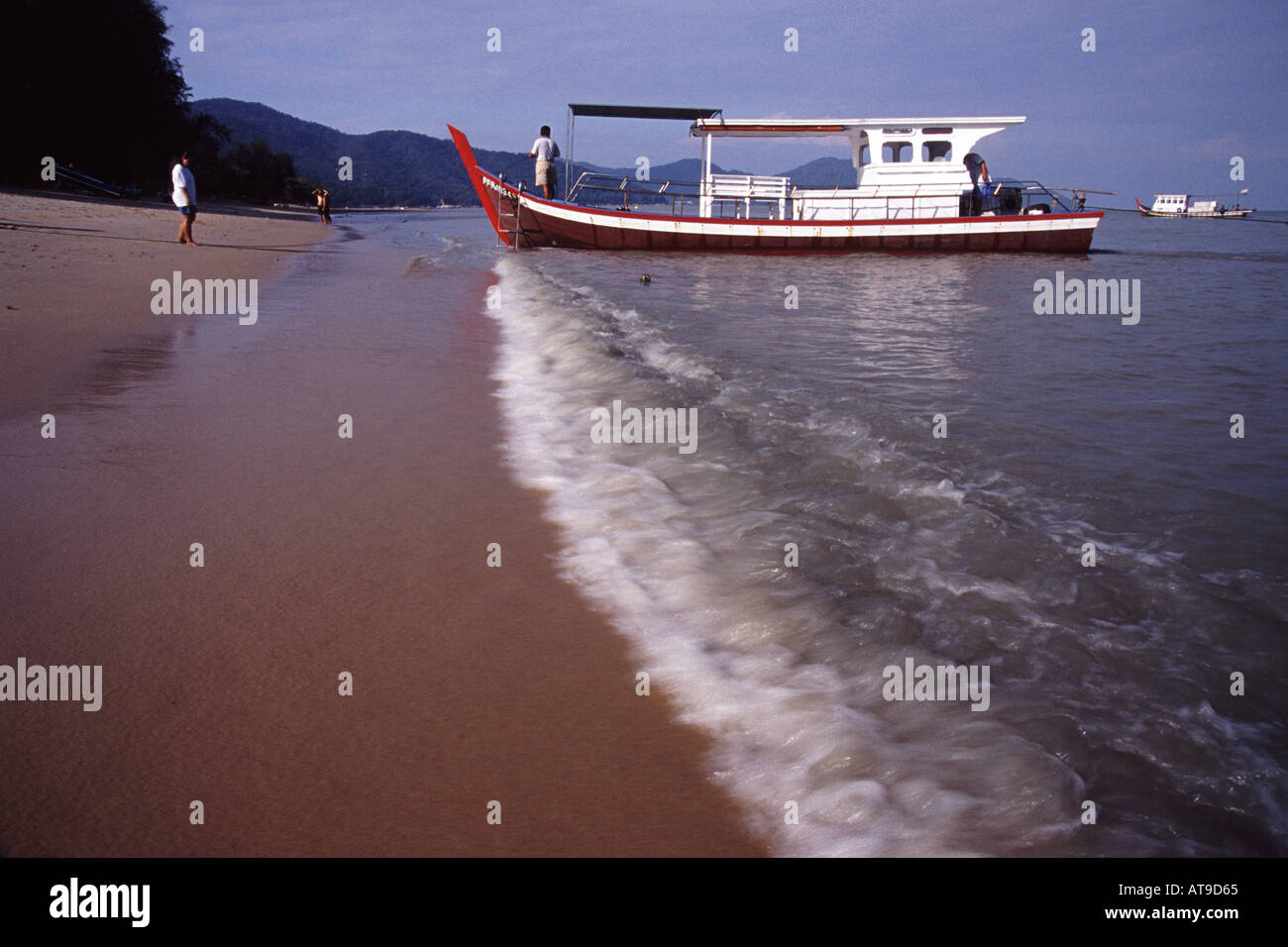 Fishing vessels rest on the beach at Penang attracting tourists Stock ...