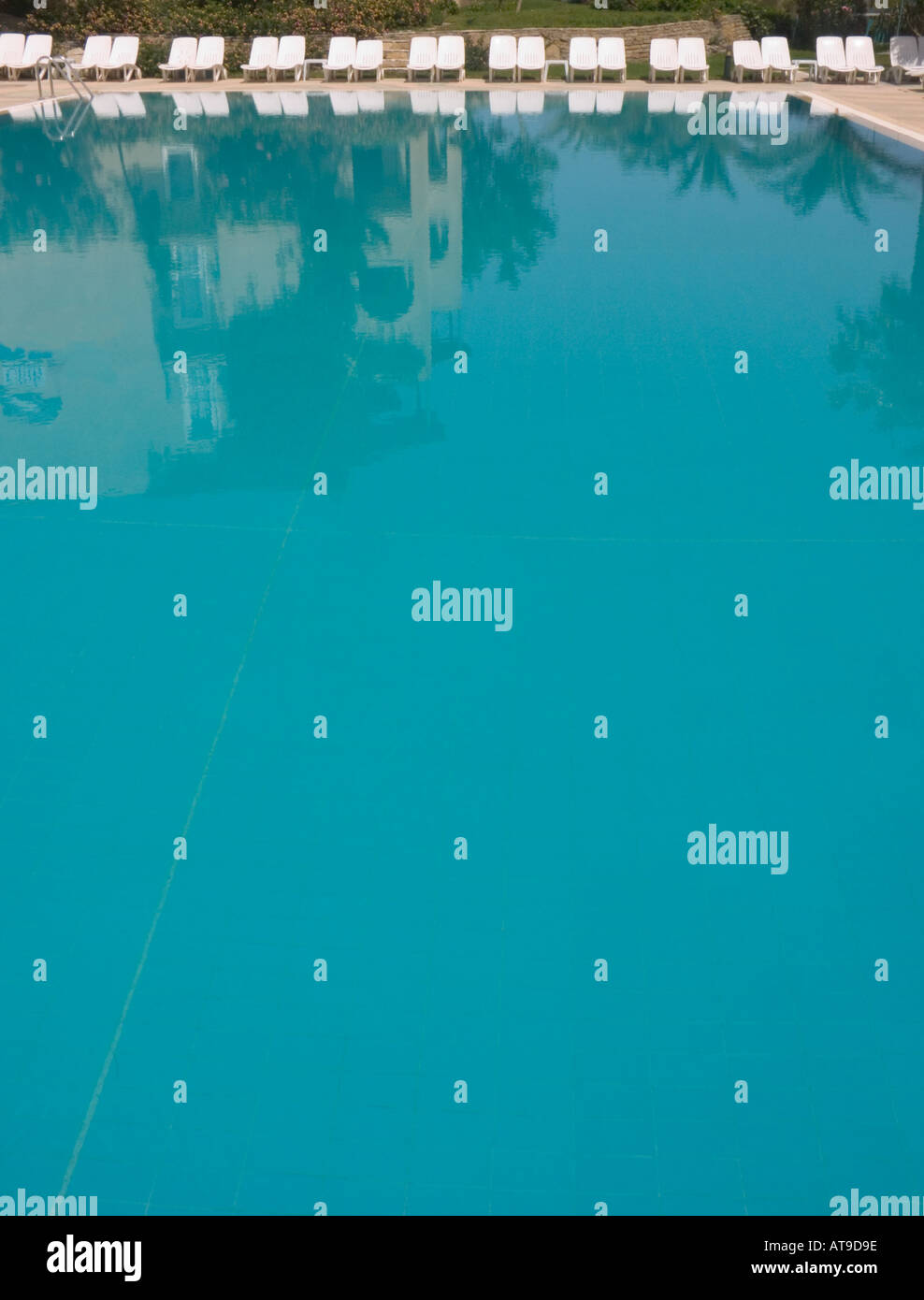 Blue swimming pool with a tiny row of empty seats neatly lined up Stock ...