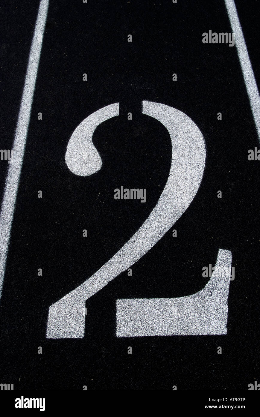 White number two on the black surface of an athletic running track ...