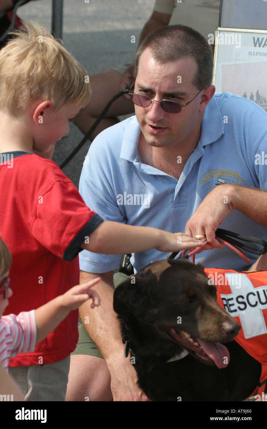 A man is talking to a little boy about rescue dogs at a Safety Fair ...